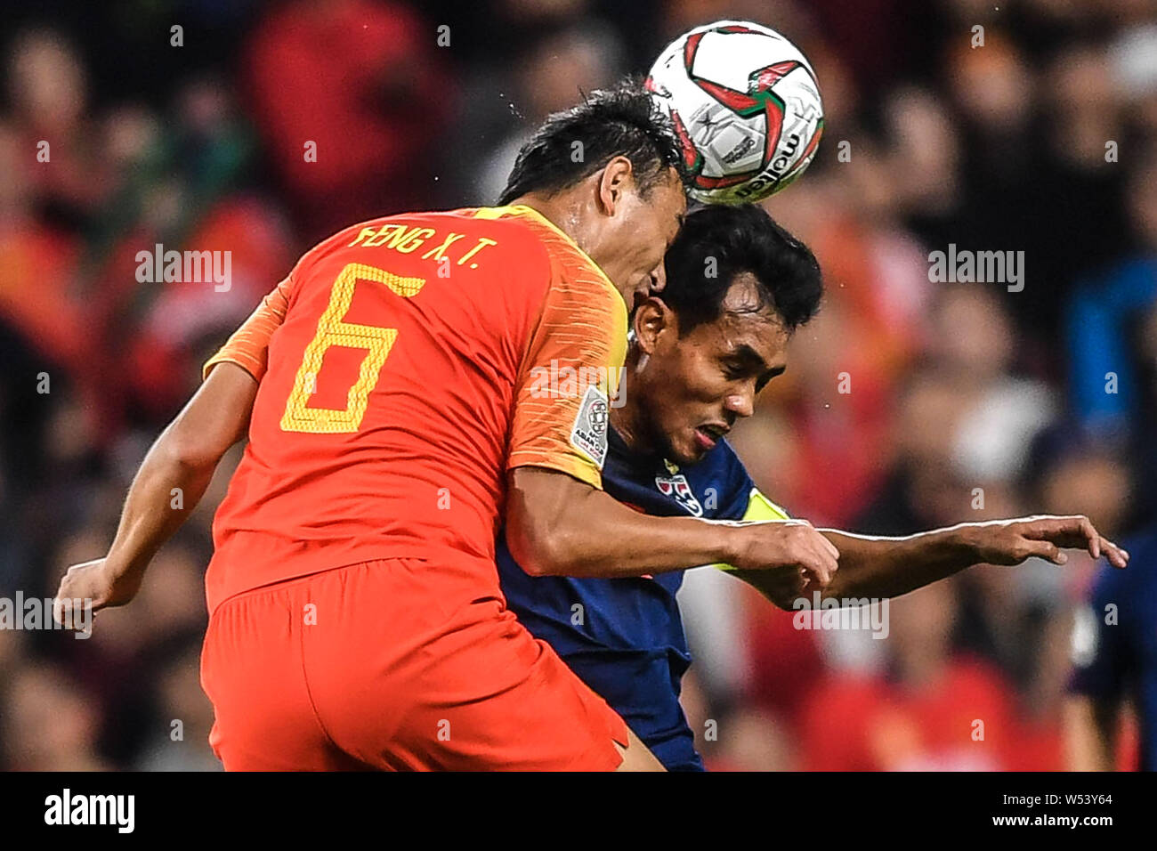 Feng Xiaoting of China, left, heads the ball against Teerasil Dangda of ...