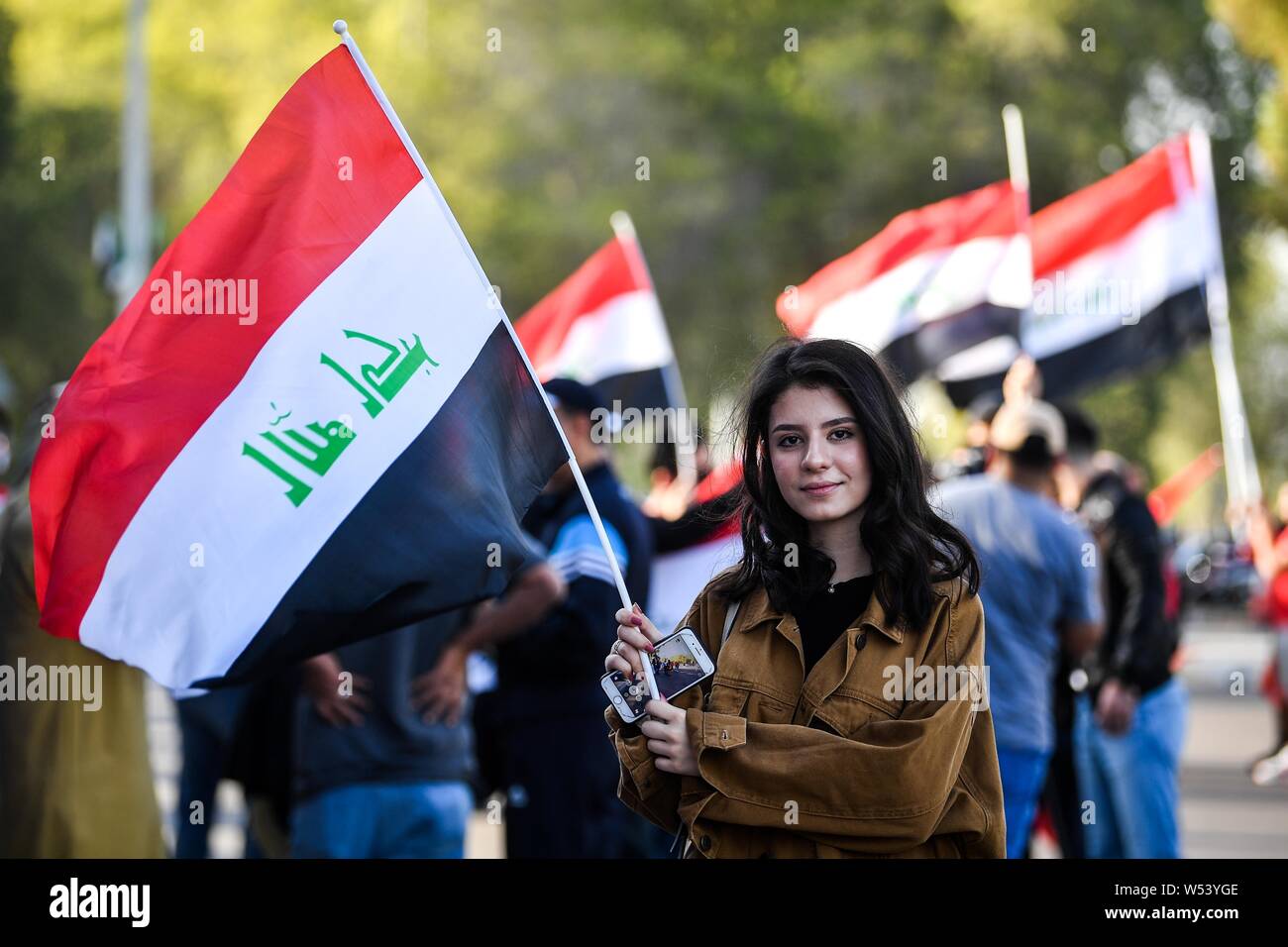 A fan holds up a national flag to show support for Iraq national ...