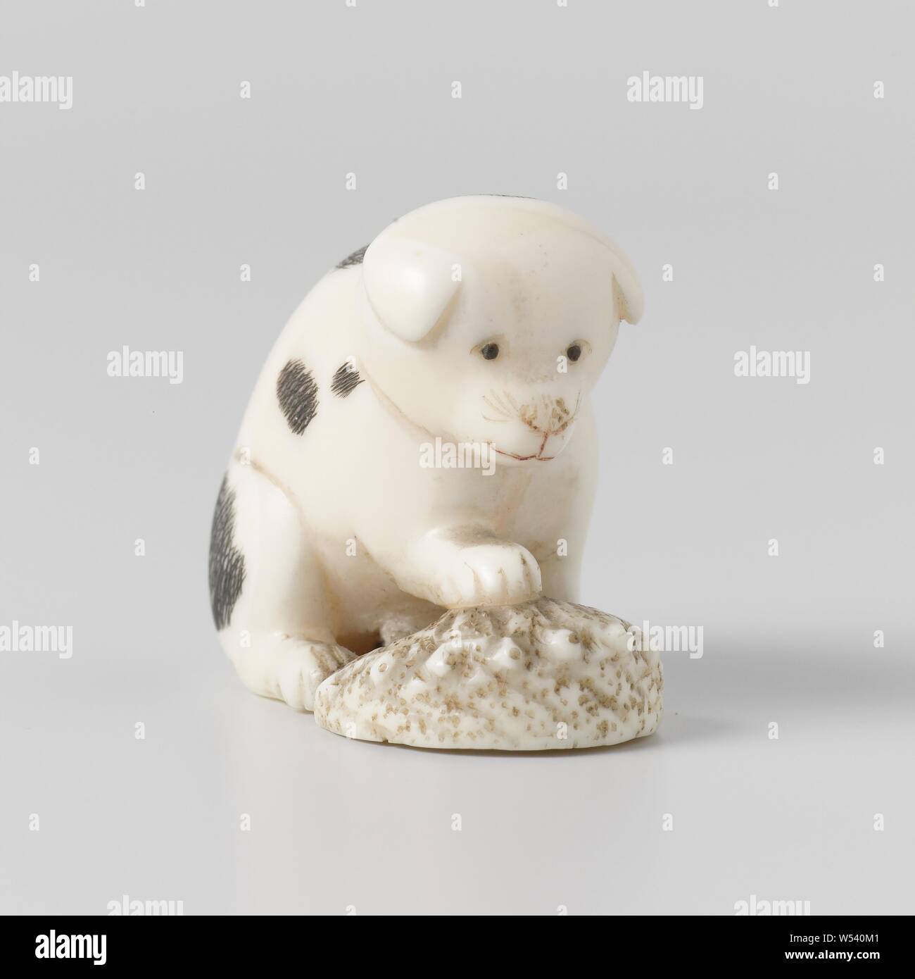Netsuke, Inu. Depiction of a young dog, mottled in black and white ...
