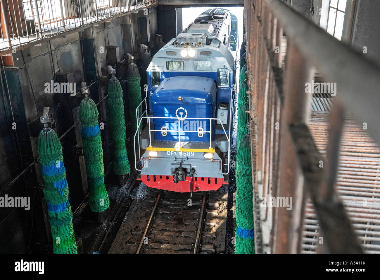 Female Chinese workers deice and clean a railway train in preparation ...