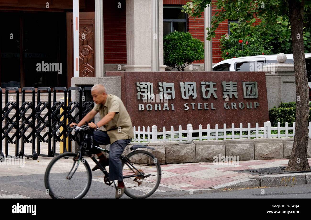 --FILE--A cyclist rides past an office building of Bohai Steel Group ...