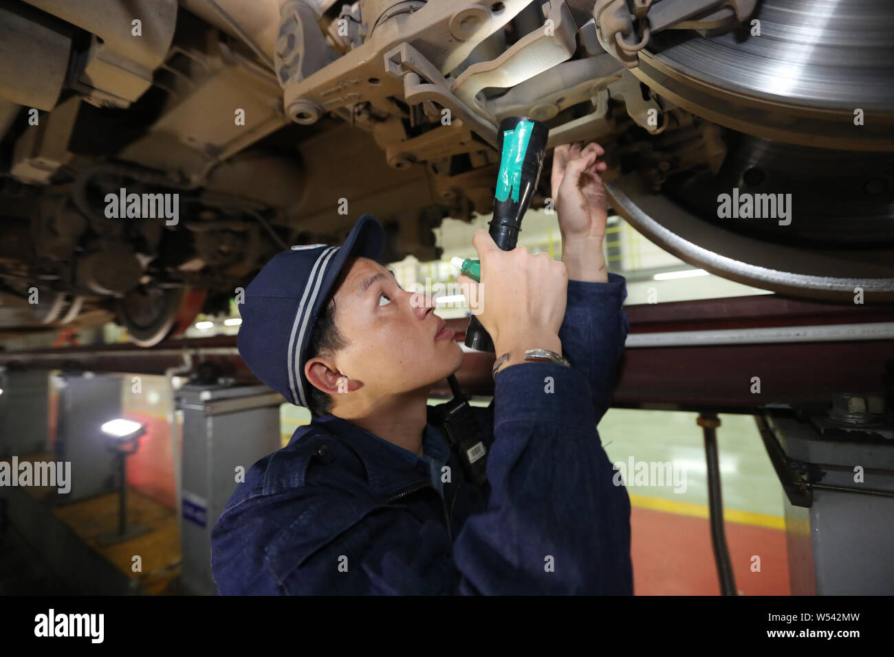 A Chinese mechanic checks a high-speed bullet train during the Spring ...