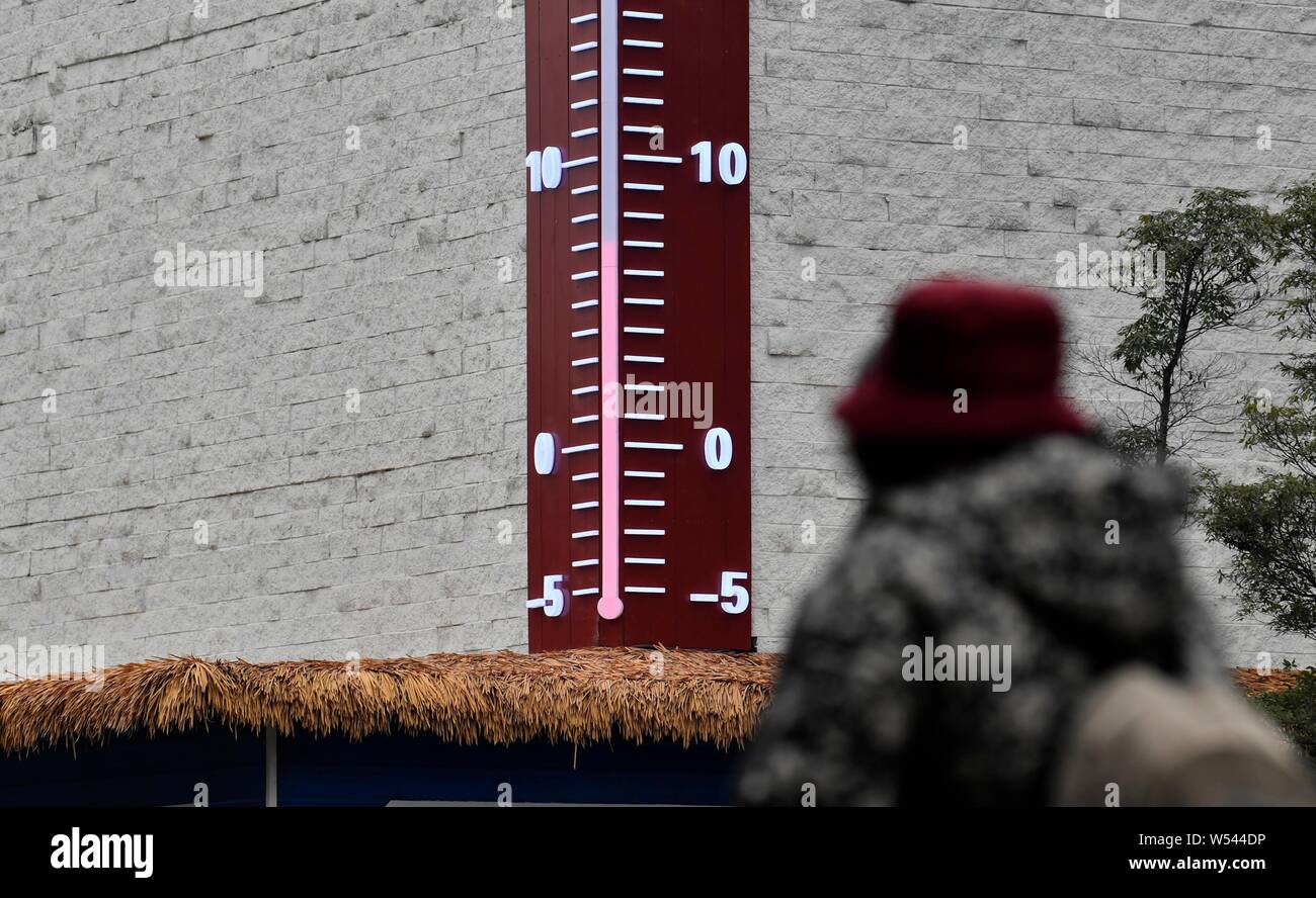 Pedestrians walk past a giant thermometer showing the current outdoor ...