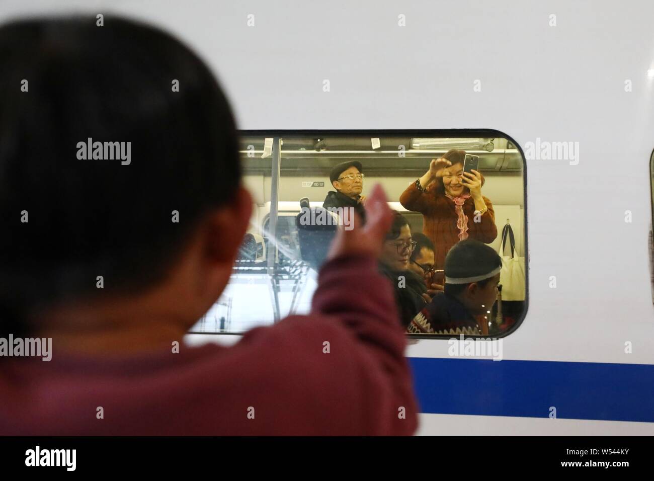 A child waves to her grandmother during the Spring Festival travel rush ...
