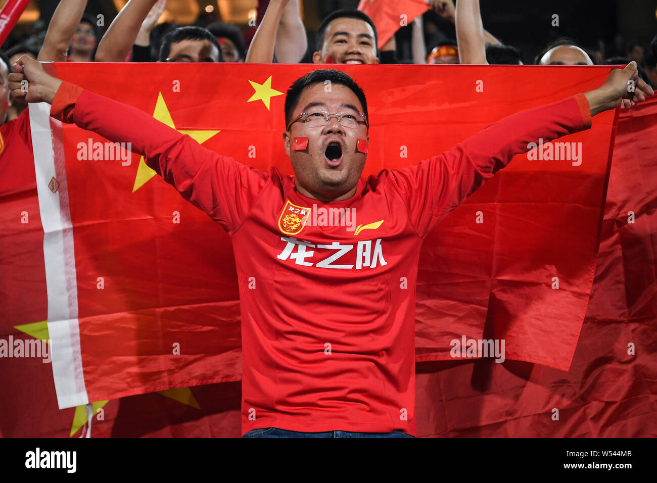Chinese fans wave slogans and national flags to show support to Chinese ...