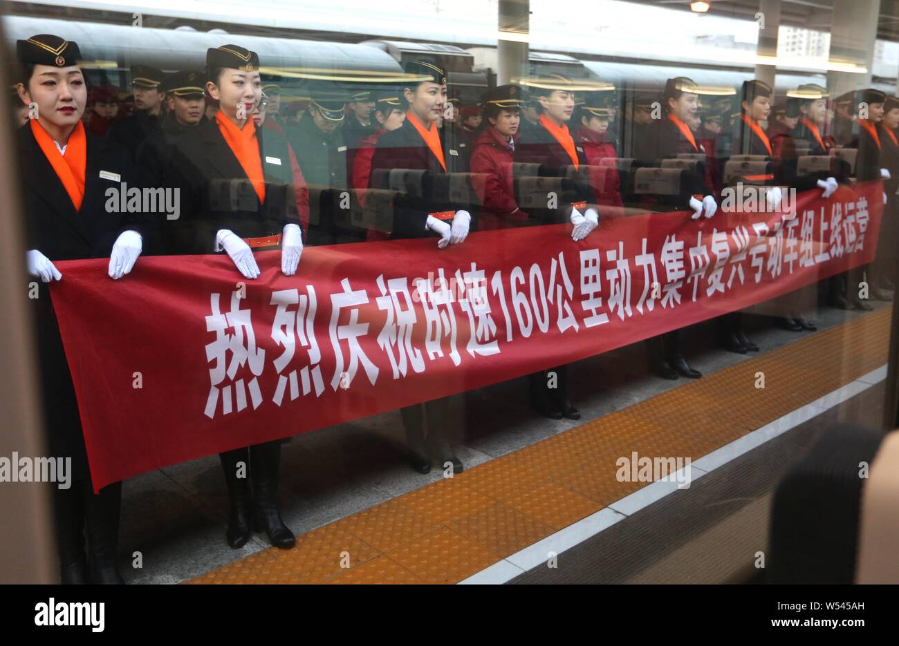 Chinese train attendants pose in front of the first Fuxing bullet train ...