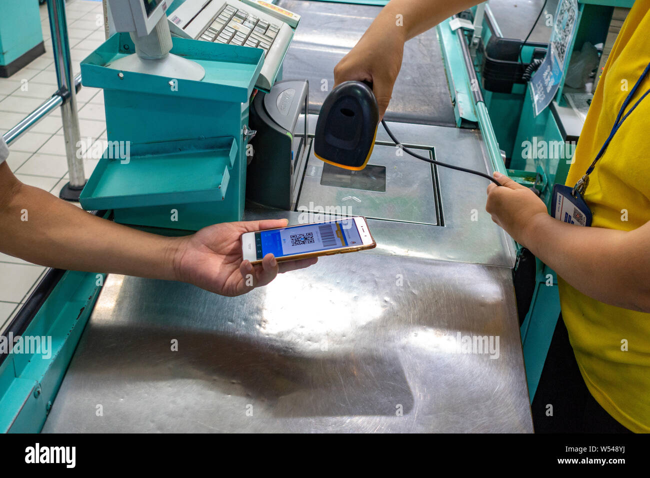 --FILE--A Chinese cashier scans the QR code through mobile payment ...