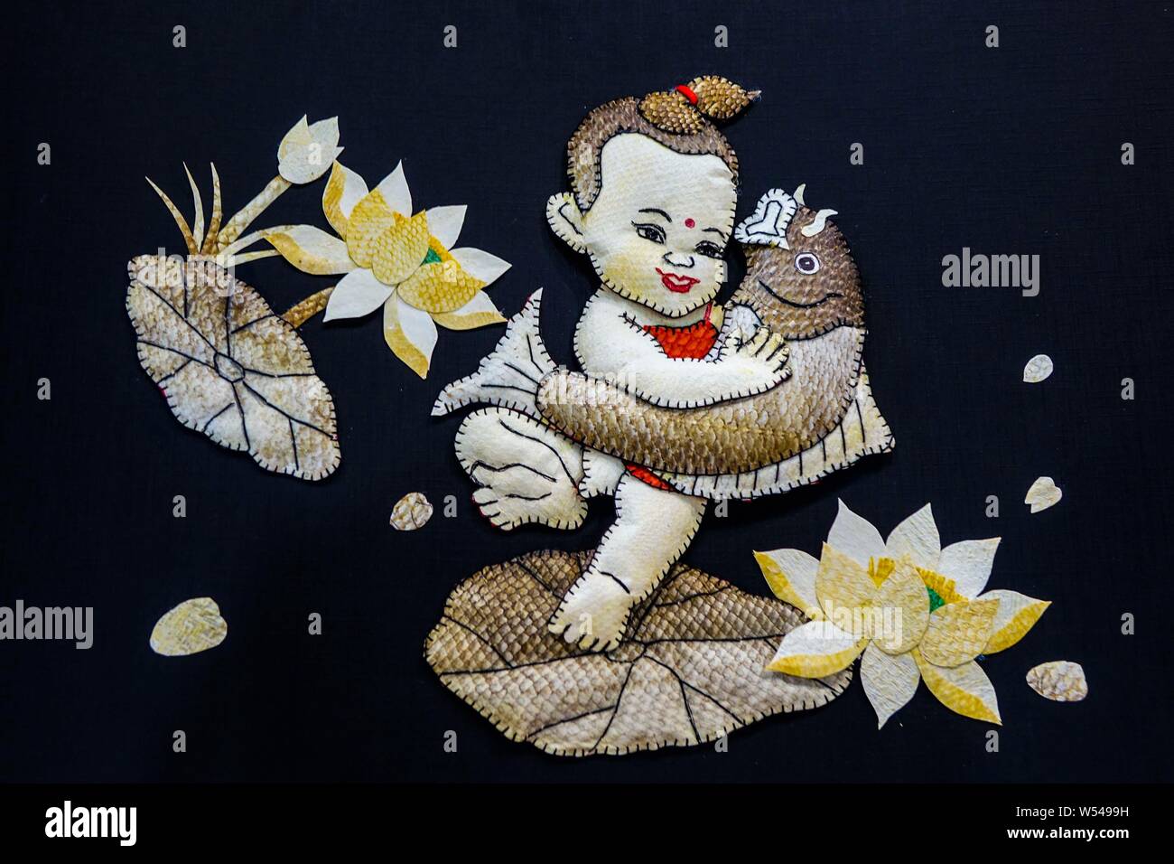 A painting made of fish skins by the Hezhen People is on display at a ...