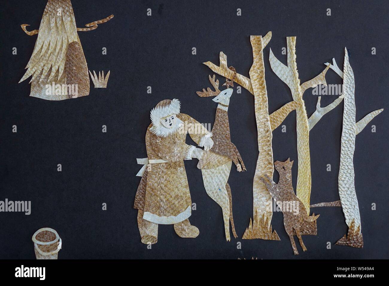 A painting made of fish skins by the Hezhen People is on display at a ...