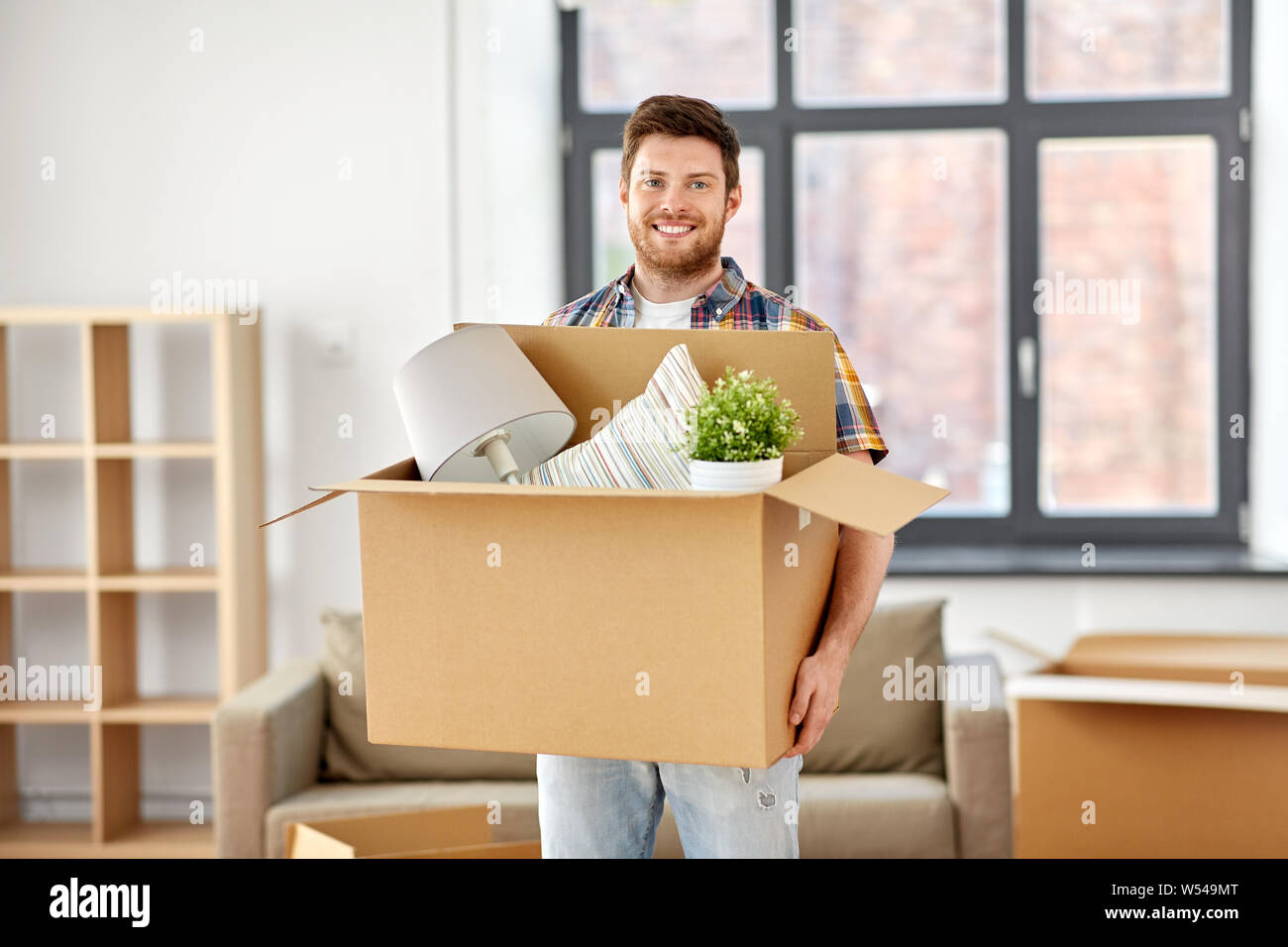 happy man with box moving to new home Stock Photo - Alamy