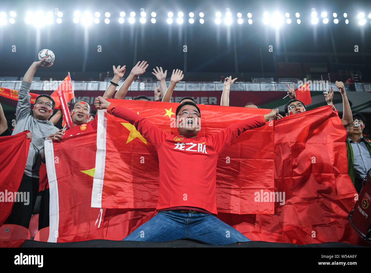 Chinese fans wave slogans and national flags to show support to Chinese ...