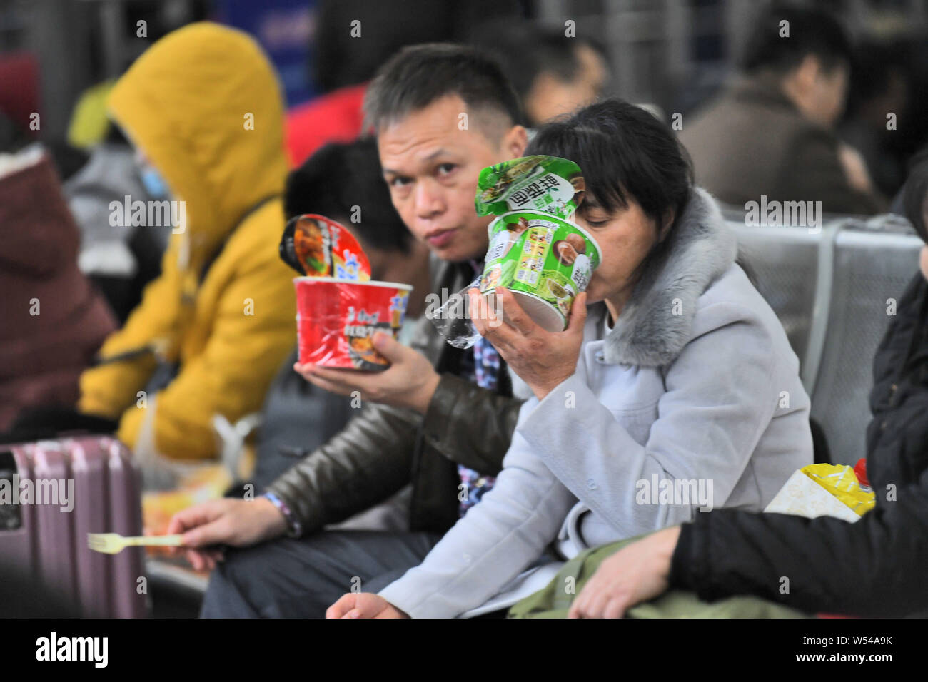 Passengers eat instant noodle as they wait for the train at the Nanning ...