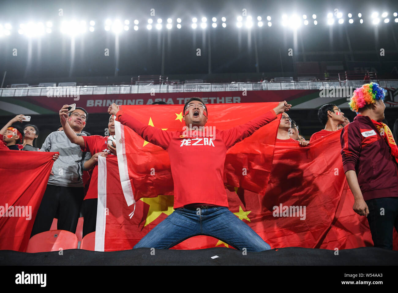 Chinese fans wave slogans and national flags to show support to Chinese ...