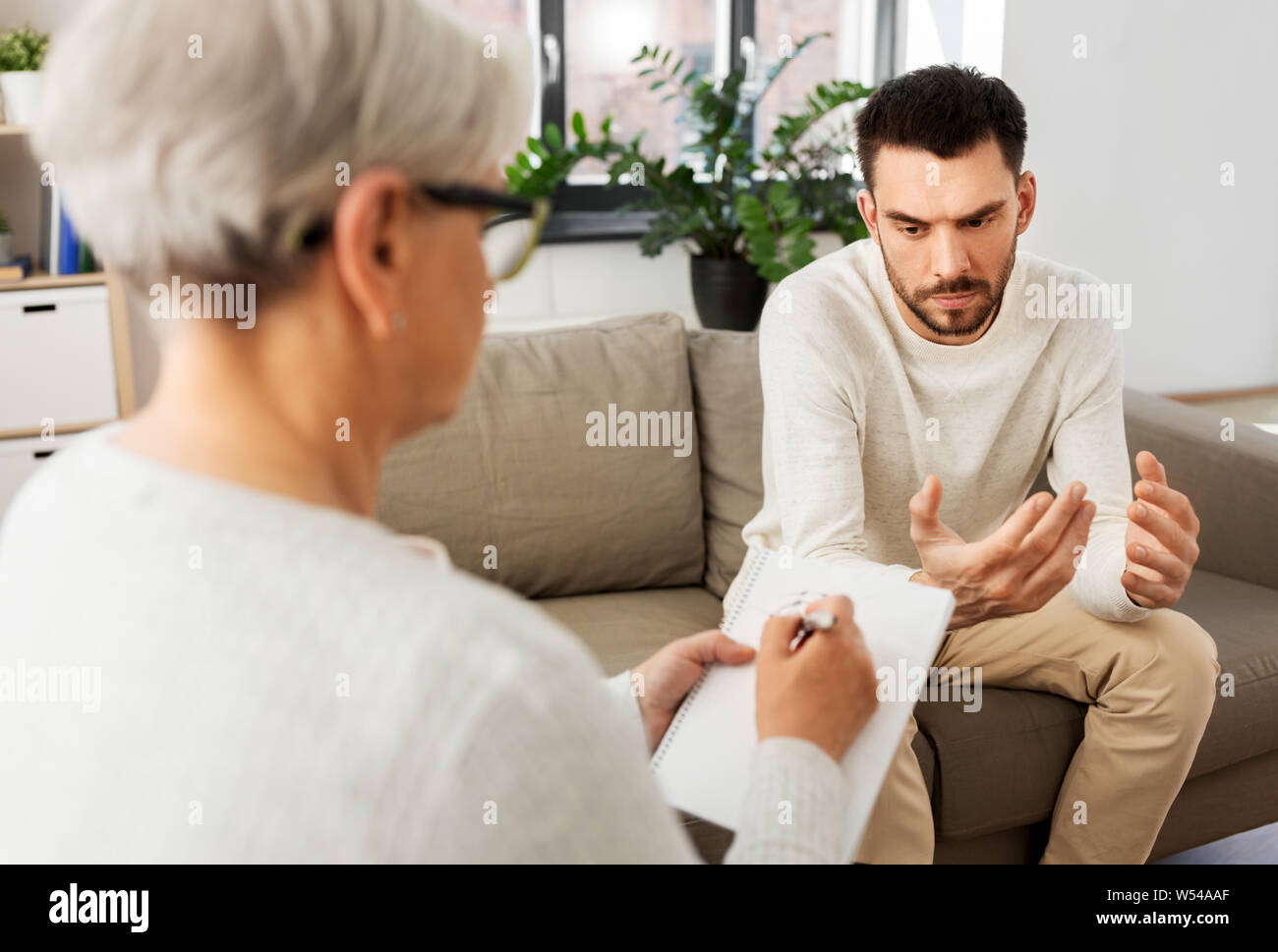 senior woman psychologist and sad man patient Stock Photo - Alamy