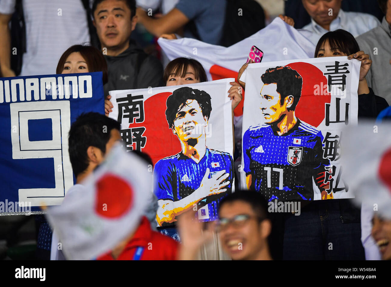 Japanese football fans wave their national flags to show support for ...