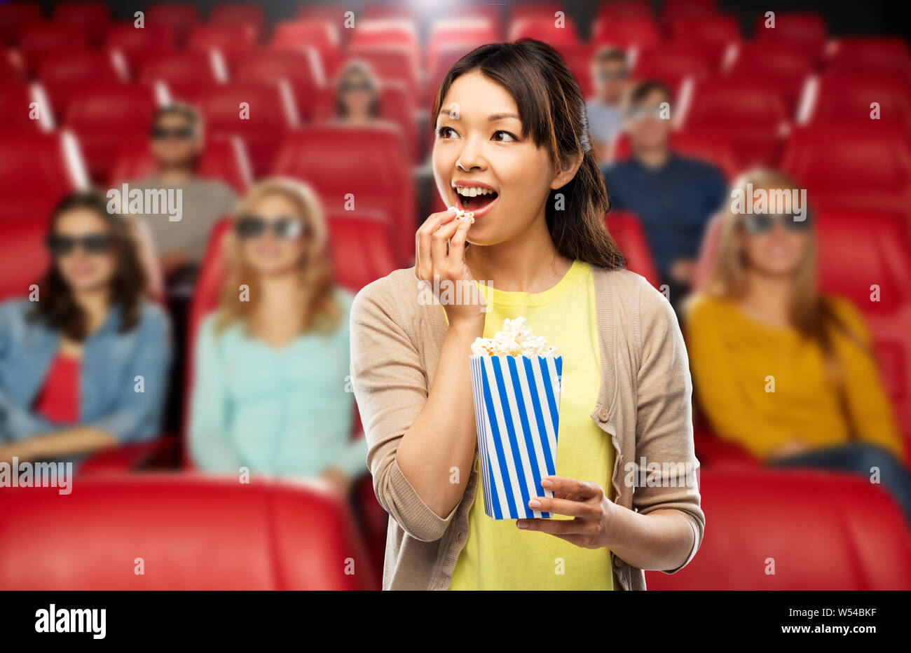 asian woman eating popcorn at movie theater Stock Photo - Alamy
