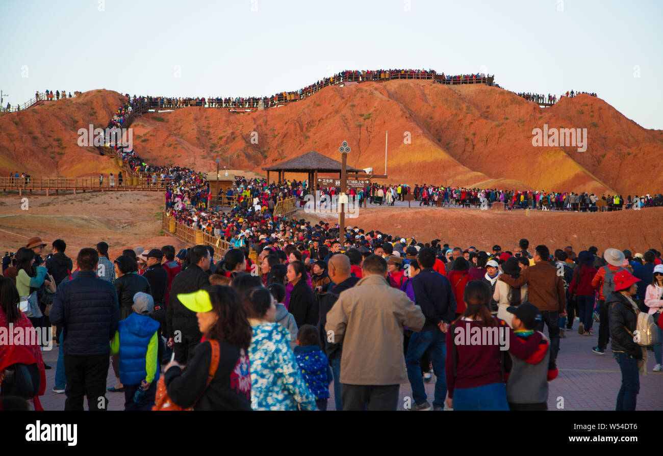 --FILE--Tourists visit the Danxia landform at the Qicai Danxia scenic ...