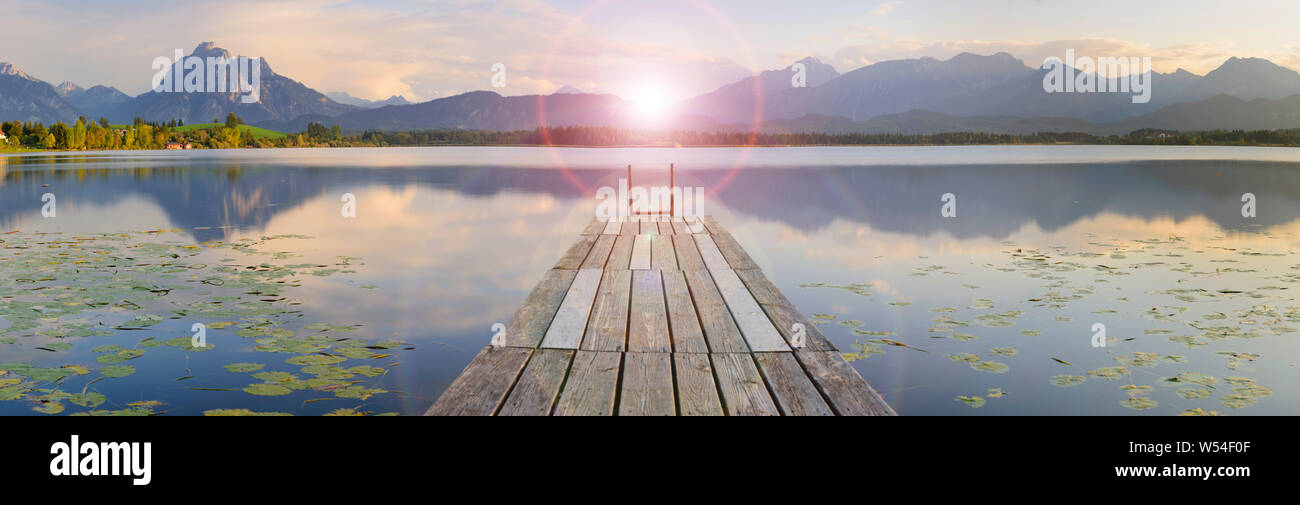 calm and panoramic scene at lake with sunrays Stock Photo - Alamy