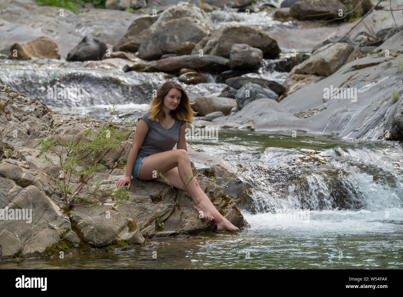 Young woman enjoying the pure waters of a mountain river Stock Photo - Alamy