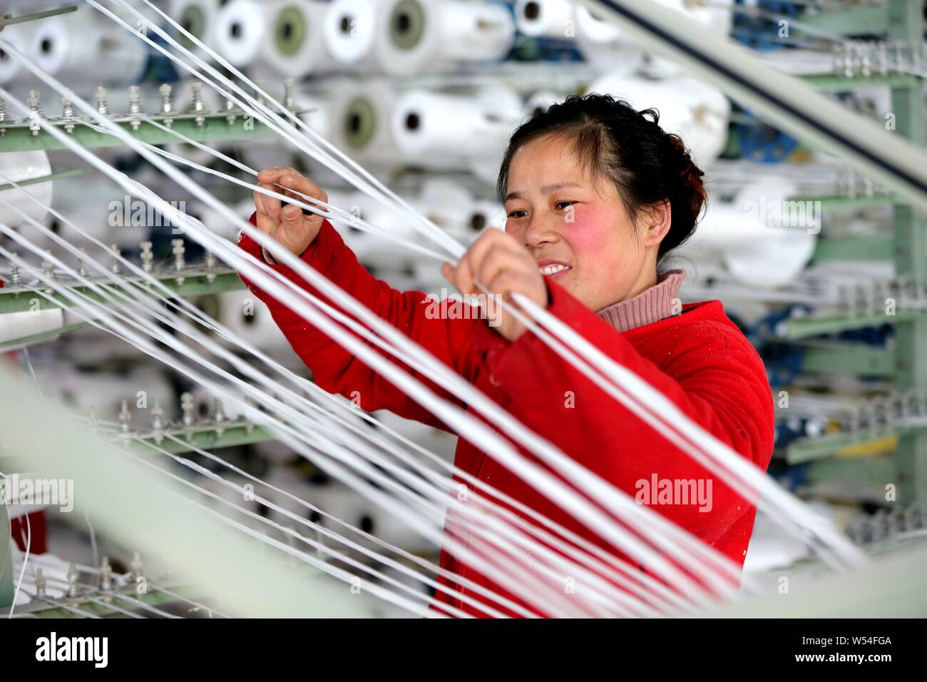 A female Chinese worker handles production of yarn at a factory in Huai ...
