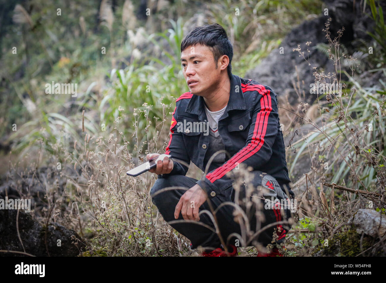 A local resident climbs a mountain in Nongli village, Bansheng town ...