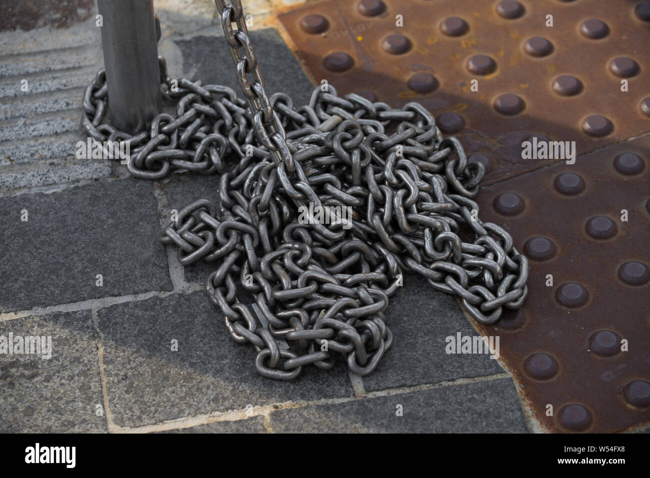 pile of iron chain attached at a pole Stock Photo - Alamy