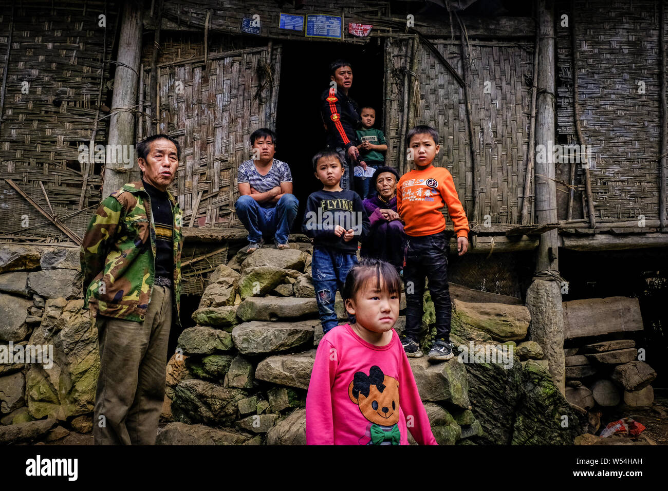 Children are seen in front of a house in Nongli village, Bansheng town ...