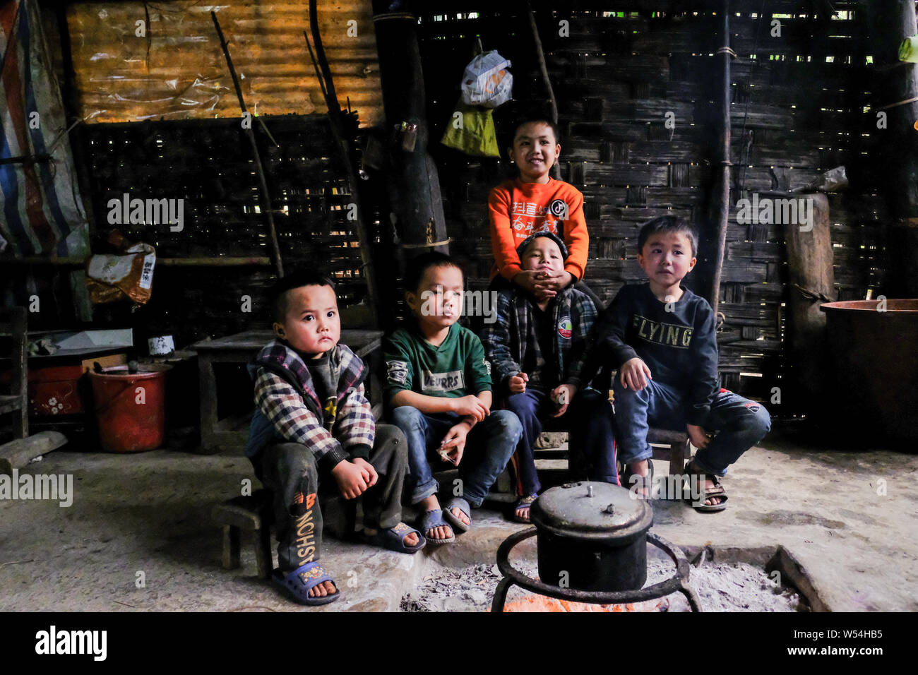 Children are seen in front of a house in Nongli village, Bansheng town ...