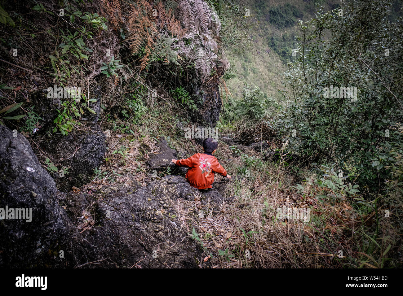 A child climbs a mountain in Nongli village, Bansheng town, Dahua Yao ...