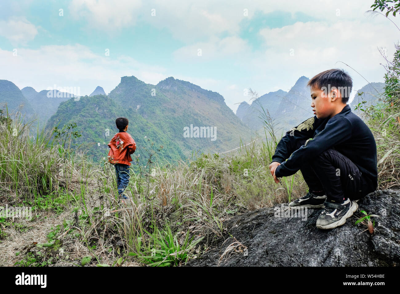 Children climb the mountains in Nongli village, Bansheng town, Dahua ...