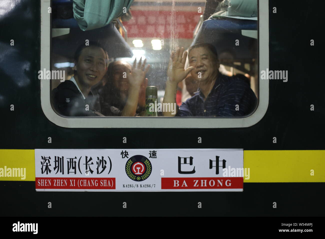 Passengers wave in a train during the Spring Festival travel rush, also ...