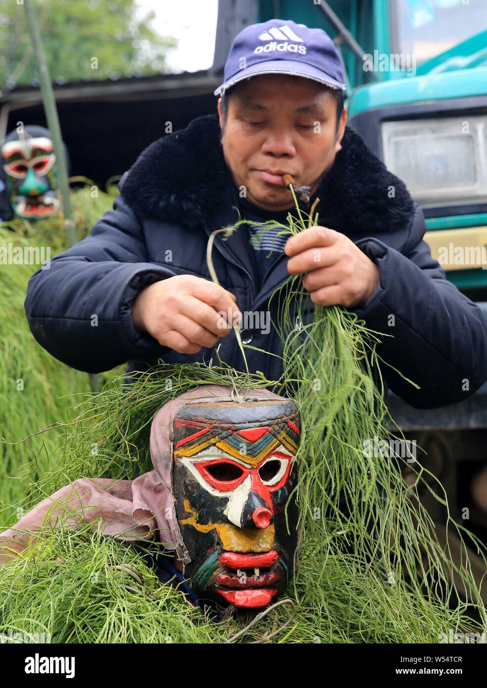 Chinese people of Miao ethnic group wearing masks and grassy cloaks ...