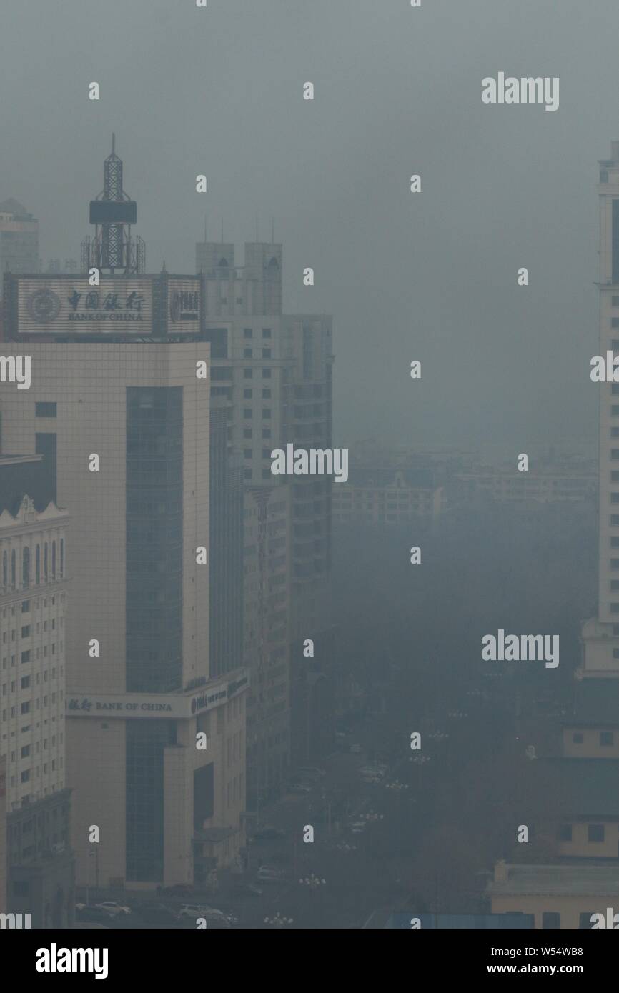 High-rising buildings and skyscrapers are seen vaguely in heavy smog in ...