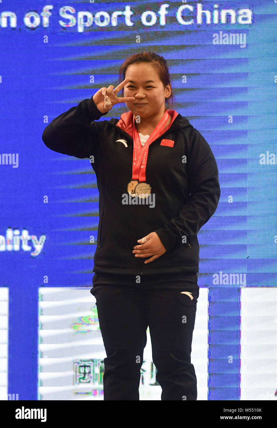 Gold medalist Zhang Wangli of China poses on the podium after winning ...