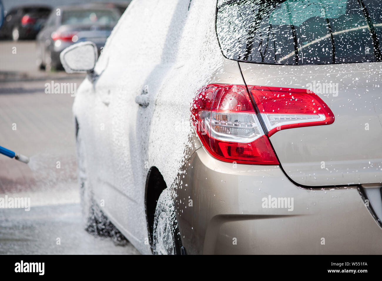 Washing car with soap. Close up concept. Open car wash. Back view of ...
