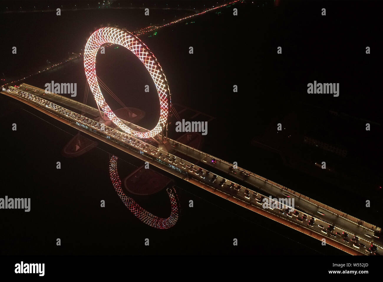 Fireworks explode beside the illuminated Bailang River Bridge Ferris Wheel, the world's largest ...