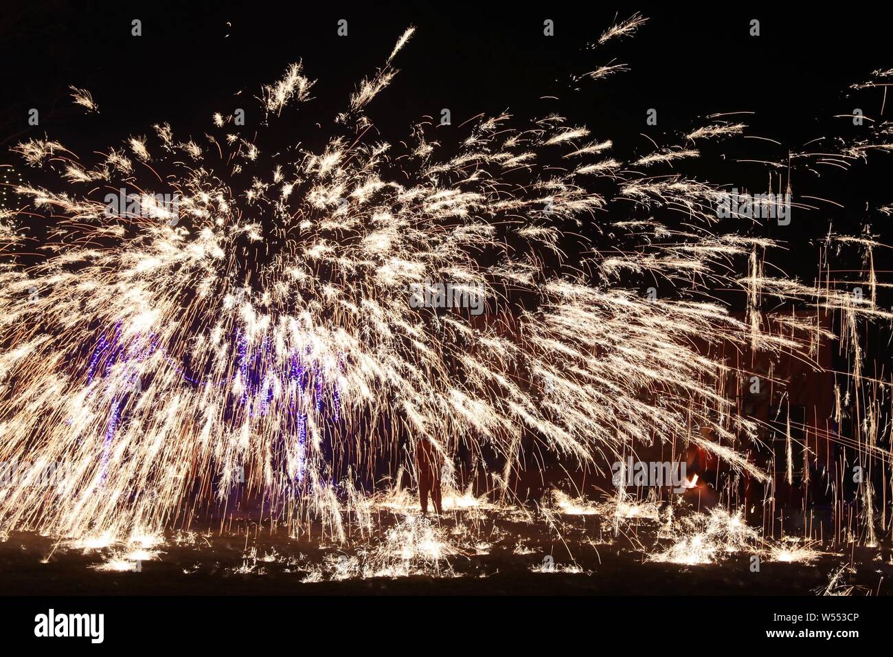 Performers spray molten iron water to create sparks into the sky during ...