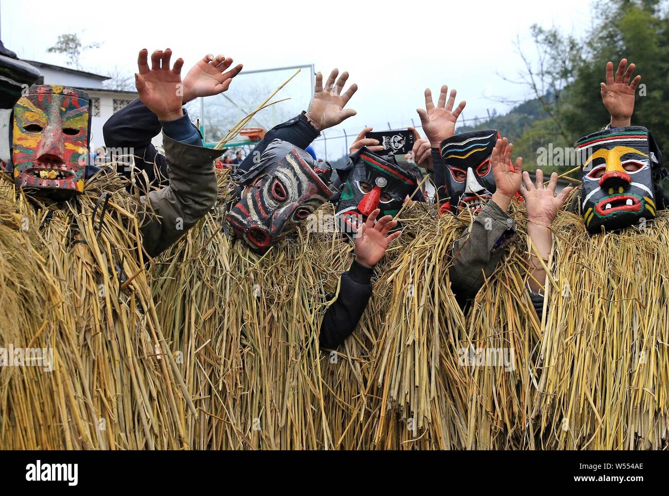 Chinese people of Miao ethnic group wearing masks and grassy cloaks ...