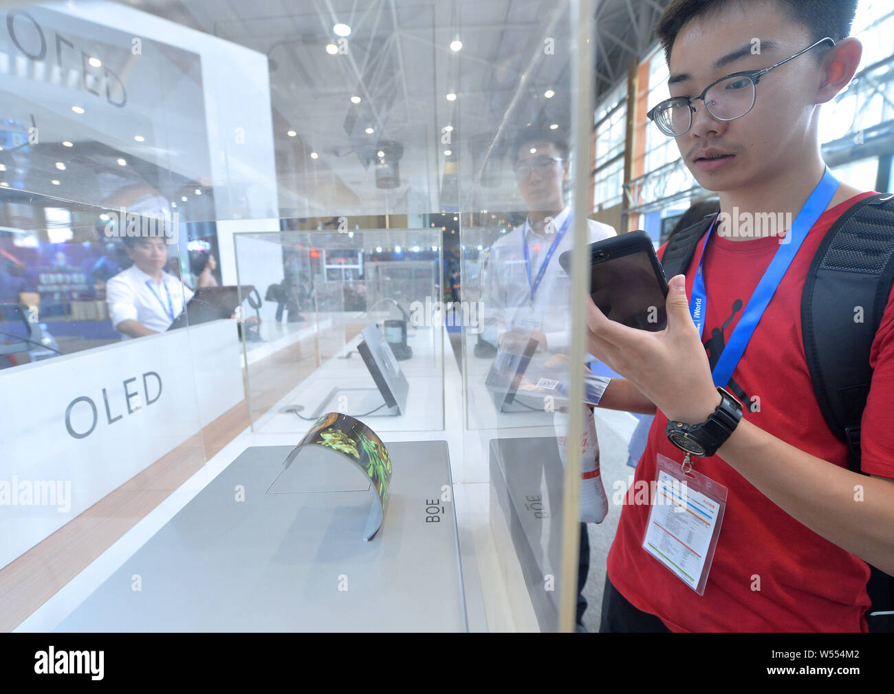--FILE--A visitor takes photos of a thin, paper-like foldable AMOLED ...