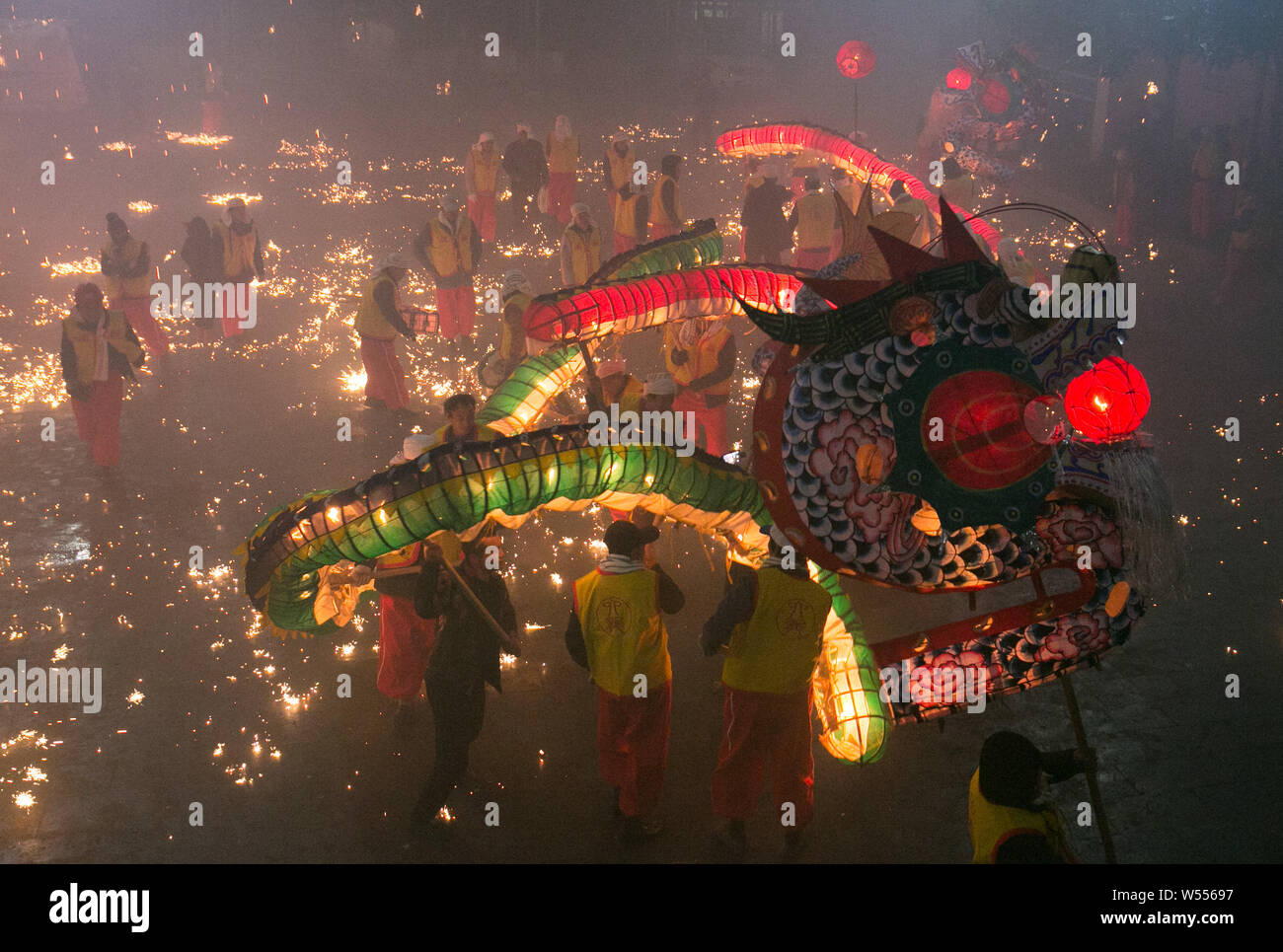 Chinese entertainers perform a fire dragon dance in a shower of molten ...