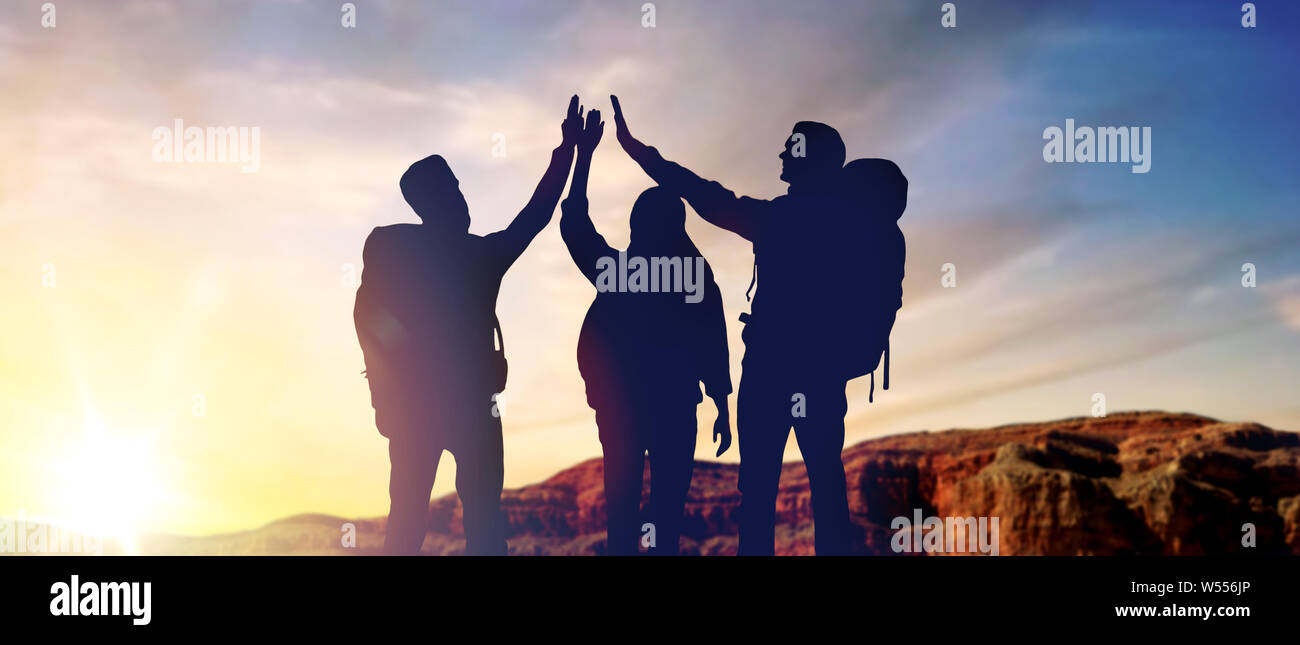 travellers making high five over sunrise Stock Photo - Alamy