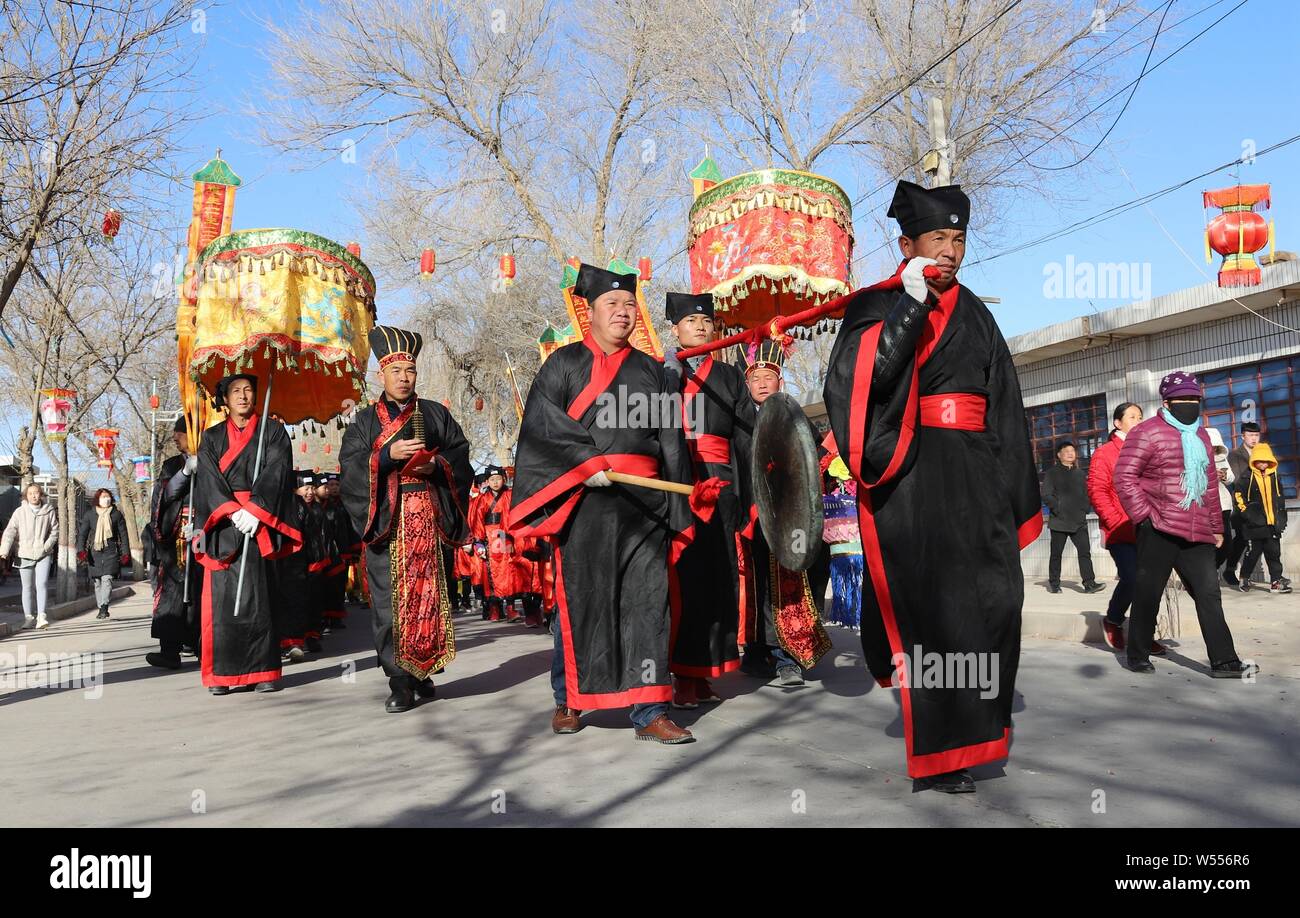 Chinese villagers dressed in traditional costumes take part inthe ...