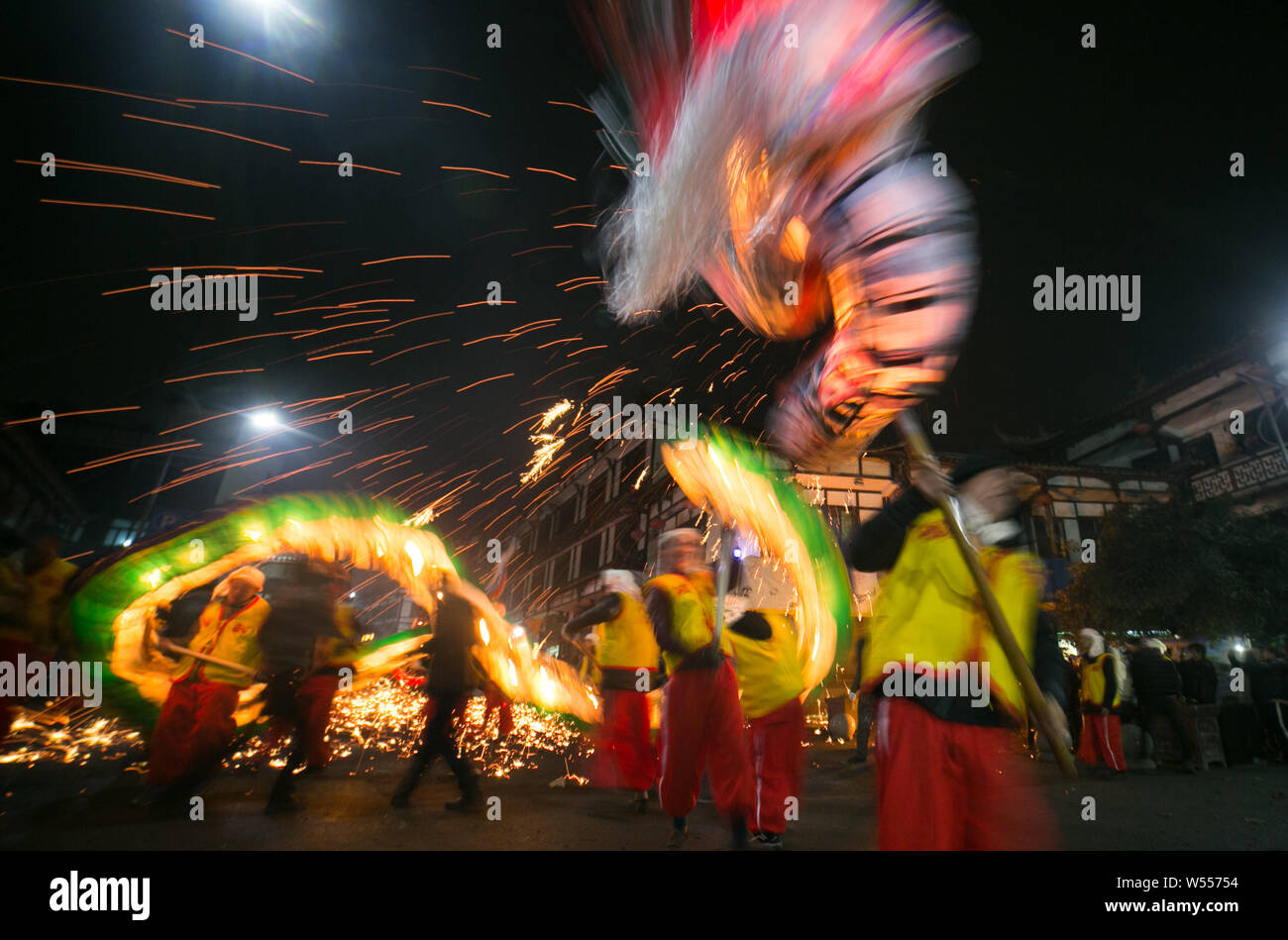 Chinese entertainers perform a fire dragon dance in a shower of molten ...