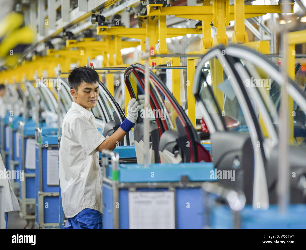 --FILE--Chinese workers assemble car engines at an auto plant of SAIC ...