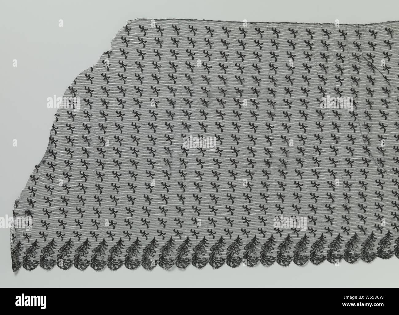 Strip of black machined lace with a bottom of j-shaped feathered leaves ...