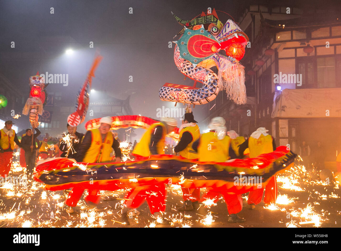 Chinese entertainers perform a fire dragon dance in a shower of molten ...