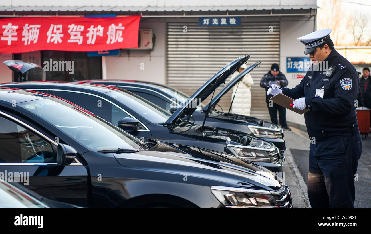 A Chinese police officer checks vehicles of BAIC Group to serve during ...