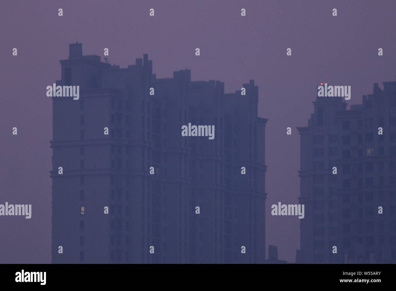 High-rising buildings and skyscrapers are seen vaguely in heavy smog in ...
