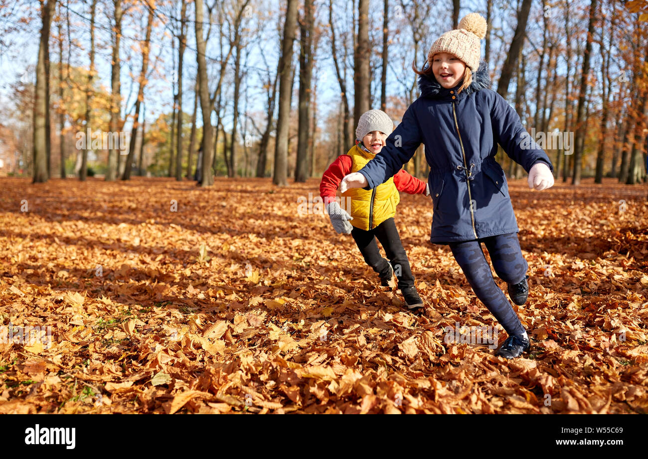 happy children running at autumn park Stock Photo - Alamy