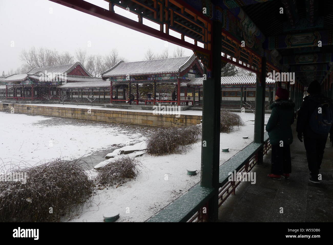 Tourists visit the Summer Palace covered with snow during a snowfall in ...